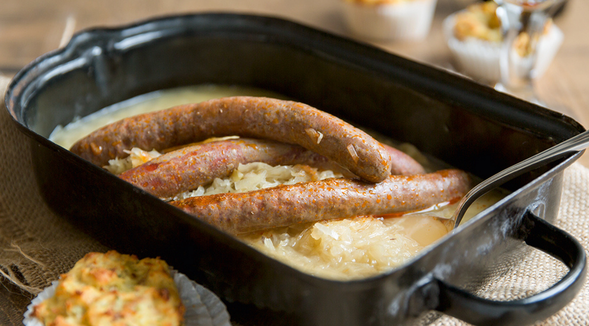 Lamb sausages in dark beer broth with chili sauerkraut and potato muff